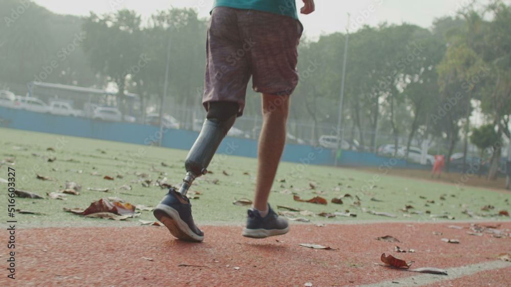 Disabled Athlete running with prosthetic leg at running track ...