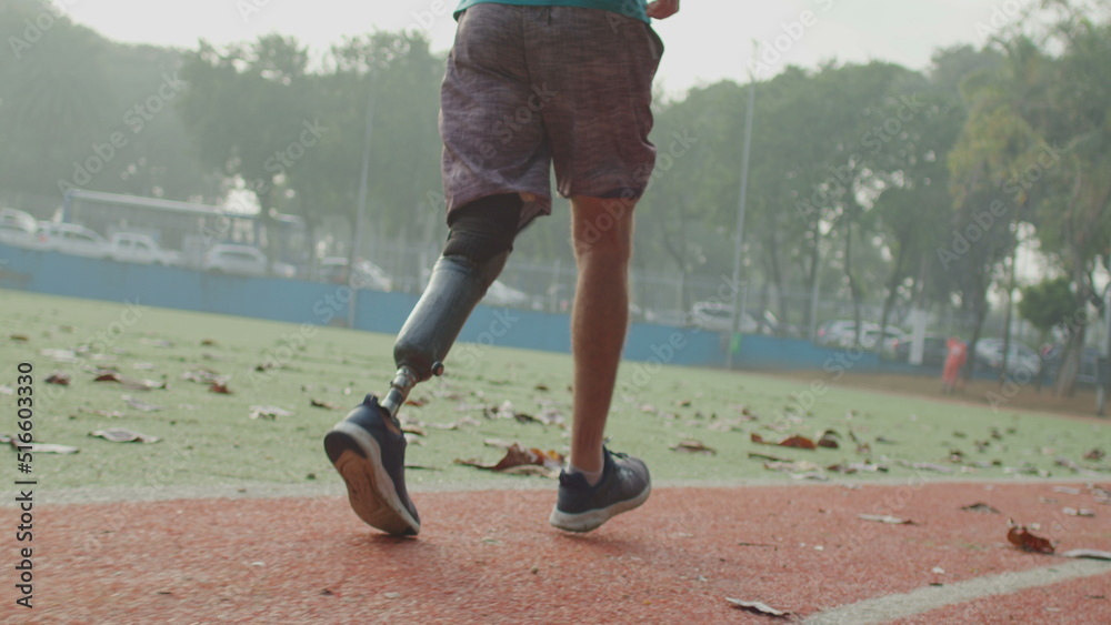 Disabled Athlete running with prosthetic leg at running track ...