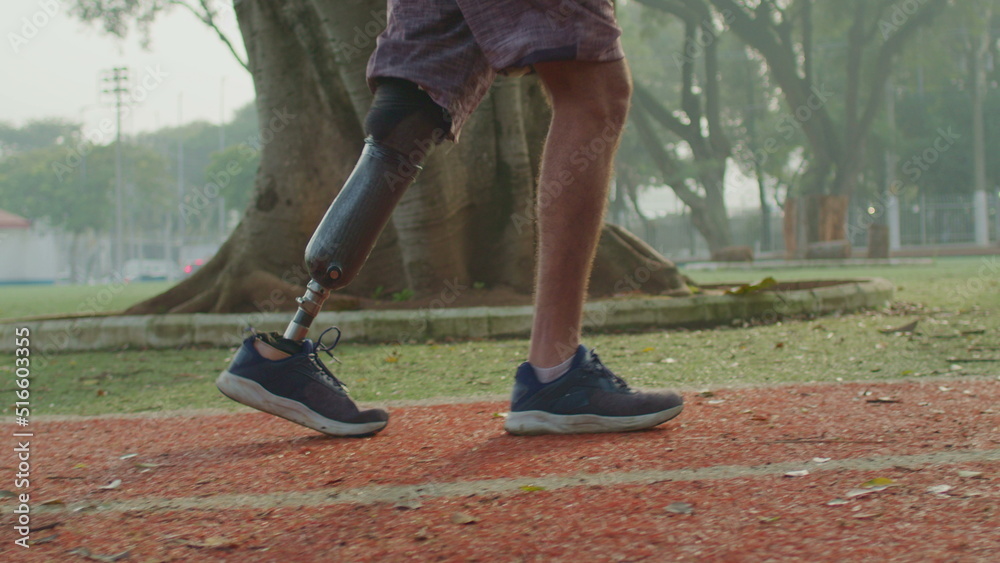 Disabled Athlete running with prosthetic leg at running track ...
