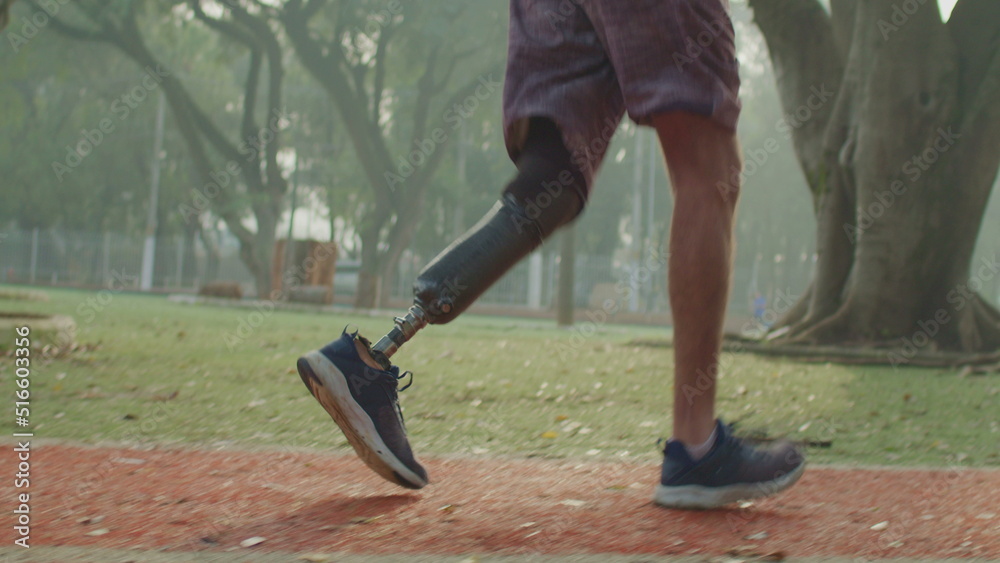 Disabled Athlete running with prosthetic leg at running track ...