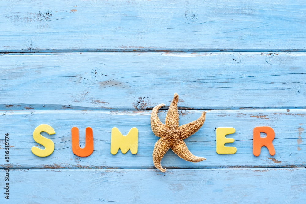 Colorful letters and starfish laid out in the word "Summer" on blue ...