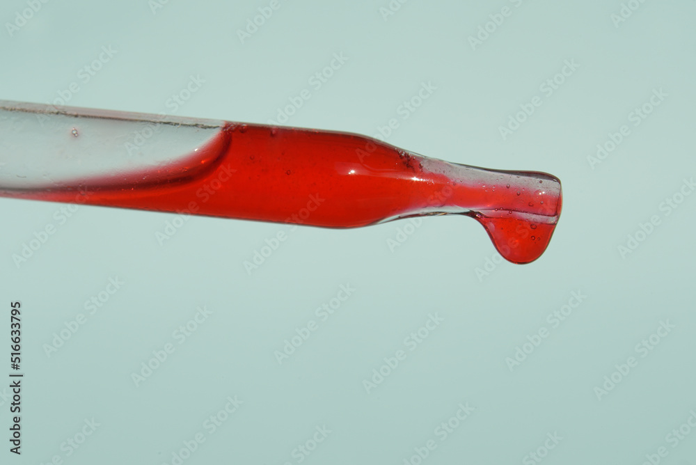 A drop of blood drips from the pipette. Blood for injection ...