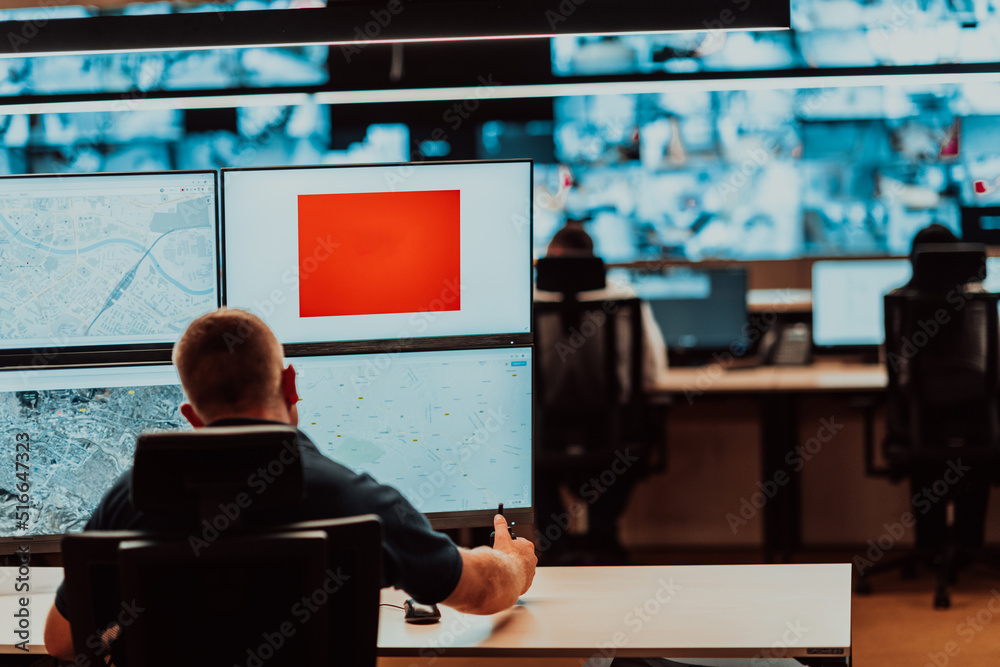 Male security operator working in a data system control room offices Technical Operator Working ...