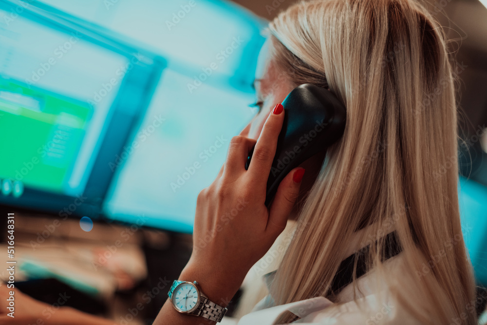 Female security guard operator talking on the phone while working at ...