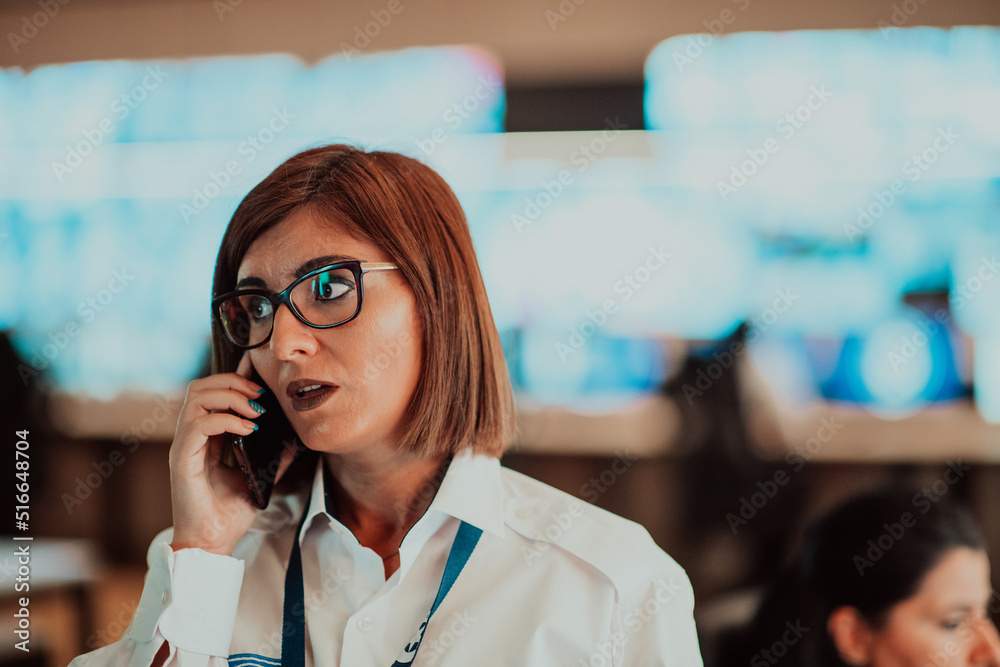 Female security guard operator talking on the phone while working at ...
