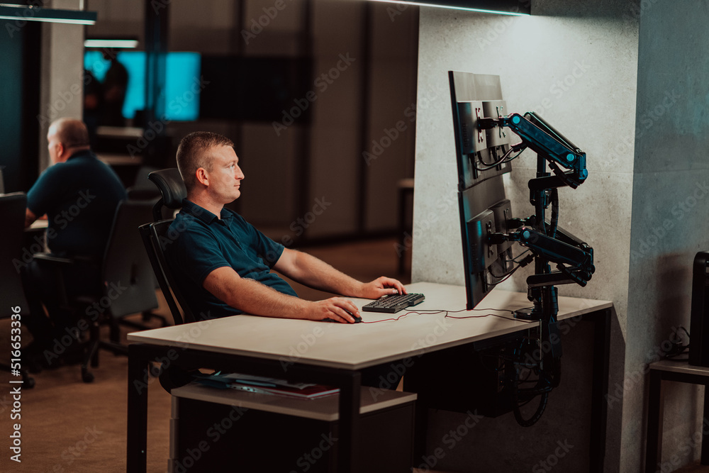 Male security operator working in a data system control room offices ...