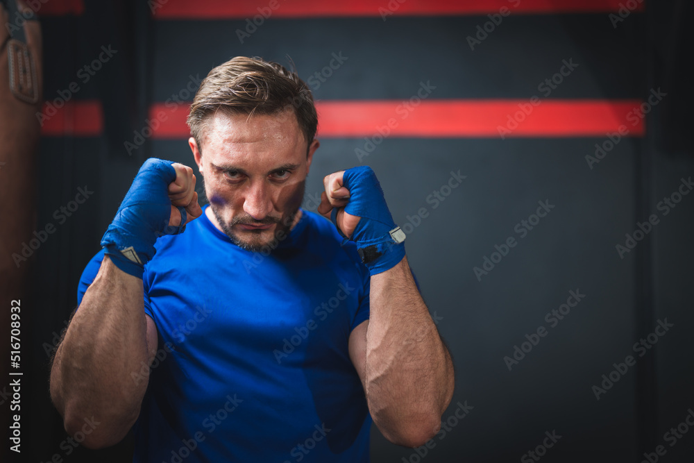 Strong man boxer in blue bandages on his hands ready to boxing fight ...