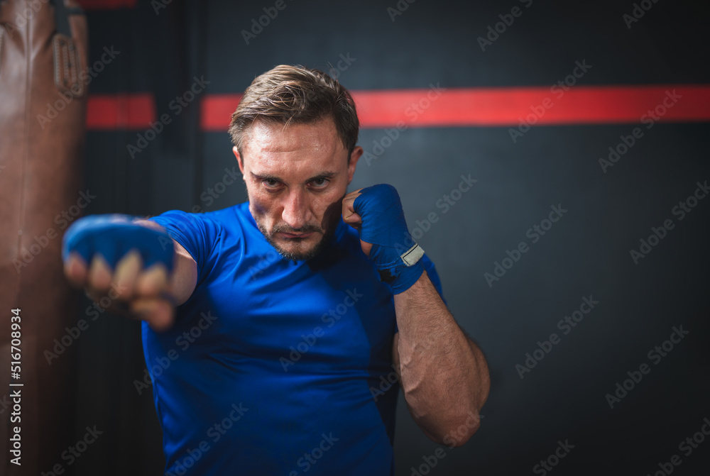 Strong man boxer in blue bandages on his hands ready to boxing fight ...
