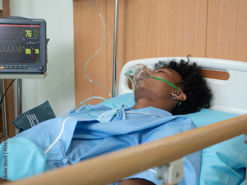 At hospital intensive care unit patient in coma lay on bed unconciousness breathing to oxygen ...