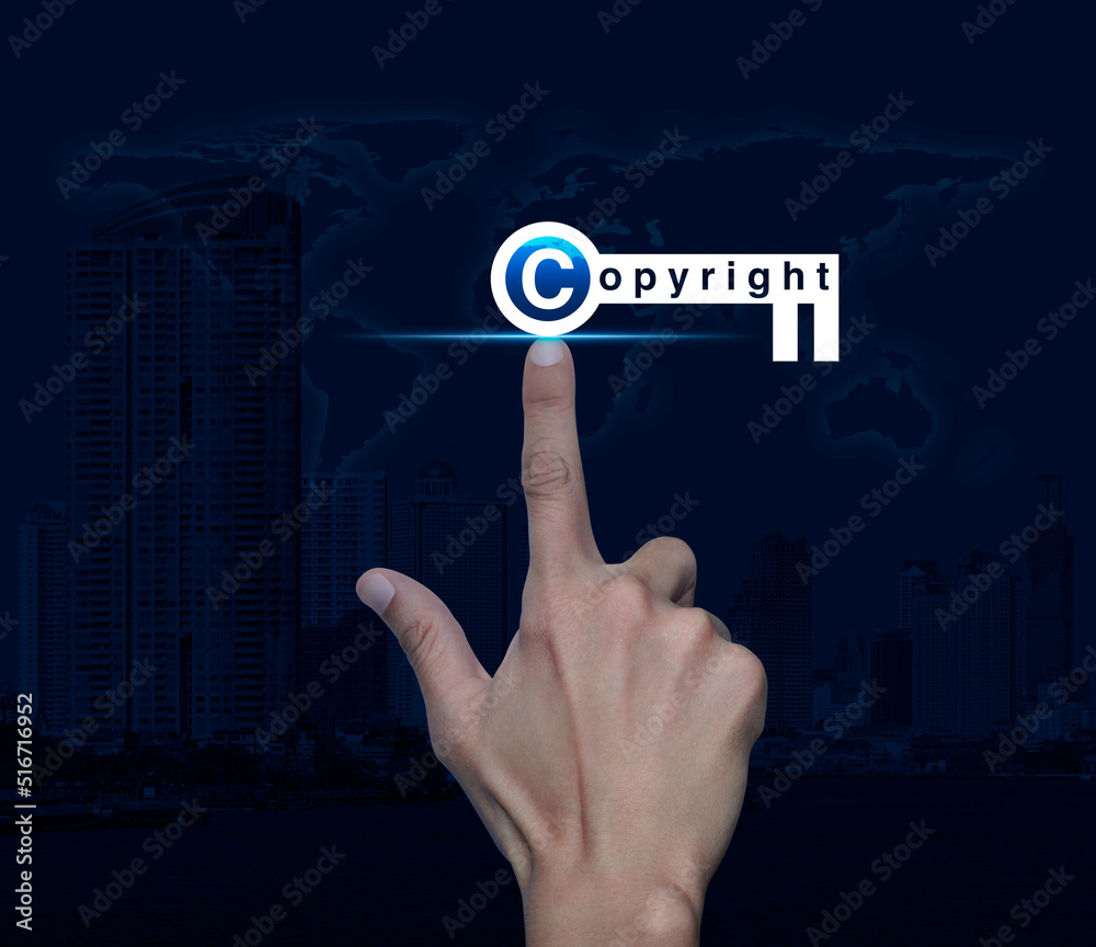 Hand pressing copyright key icon over world map, modern city tower and ...