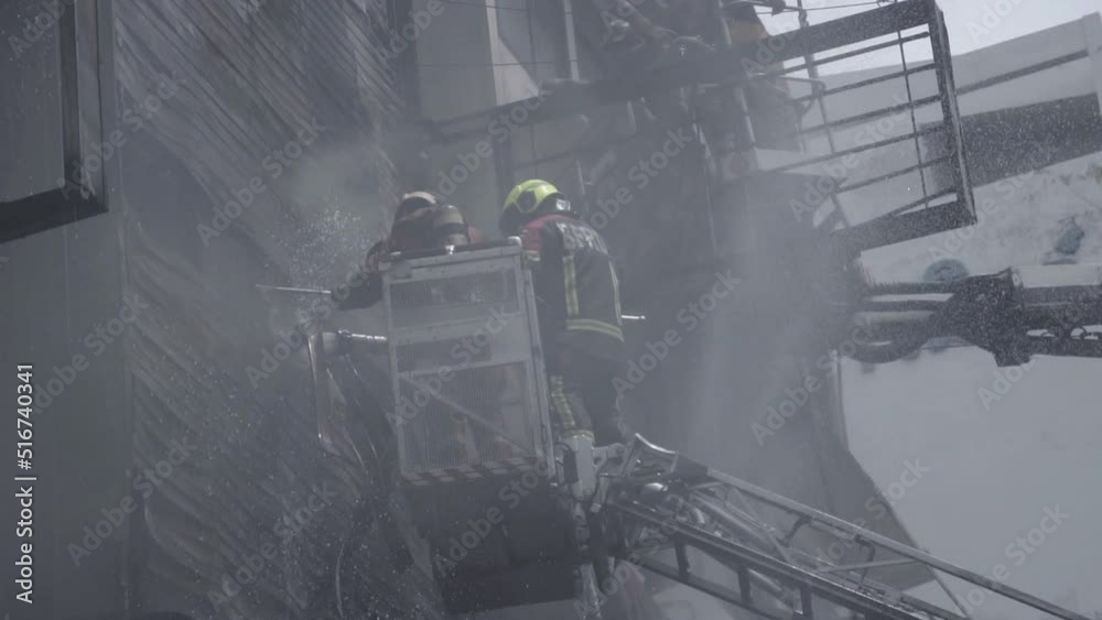 Firefighters climbing Ladder to extinguish the fire burning building ...