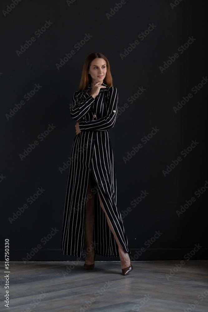 young girl with a slim figure in a black and white striped dress, full ...
