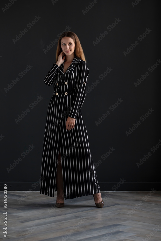 young girl with a slim figure in a black and white striped dress, full ...