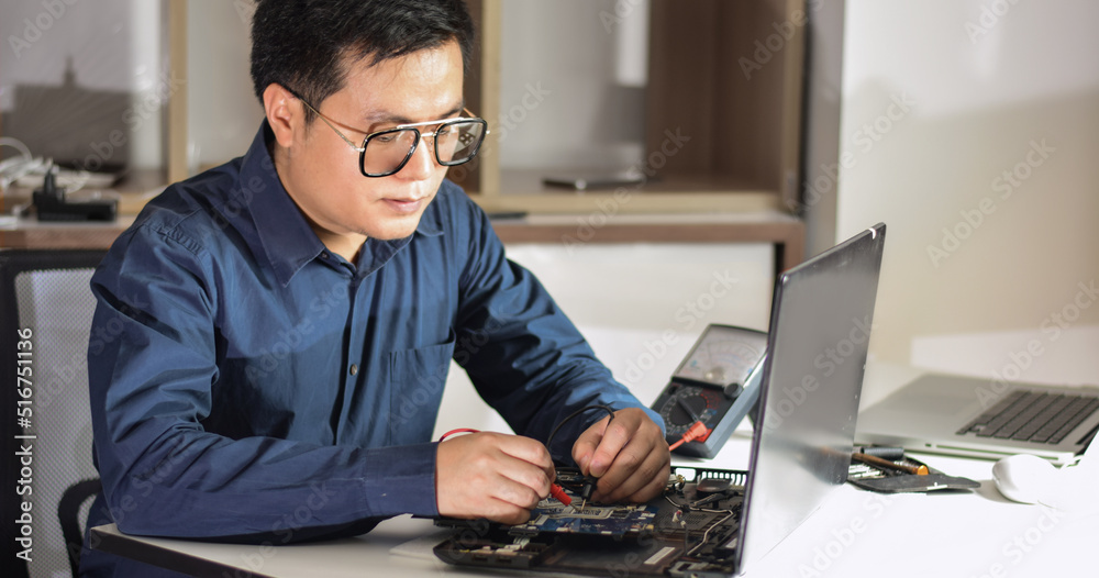 a young man wearing glasses who is a computer technician A laptop ...