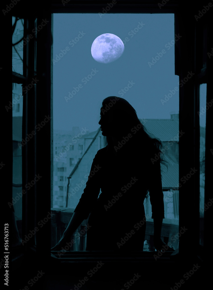 full moon in the night dark blue sky. Black silhouette of young slim ...