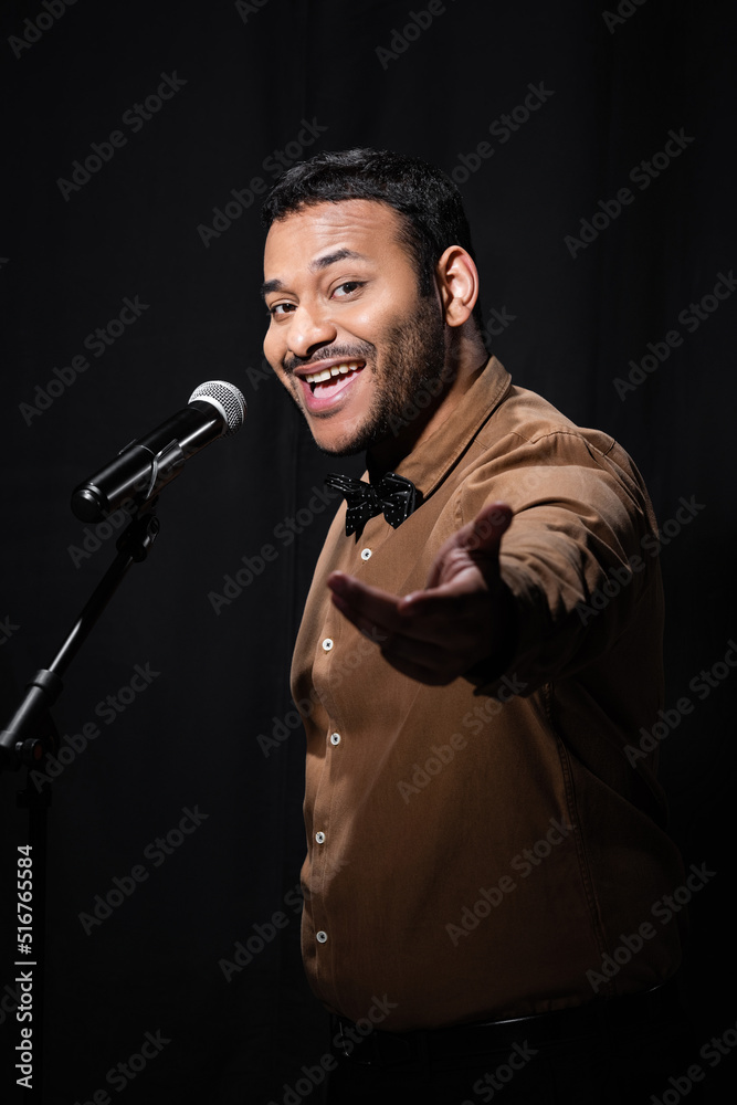 amazed indian stand up comedian telling jokes into microphone on stand ...