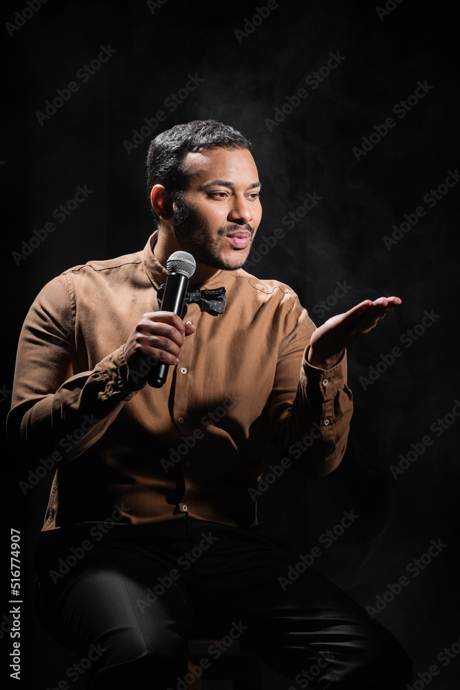 indian comedian sitting and pouting lips while performing stand up ...