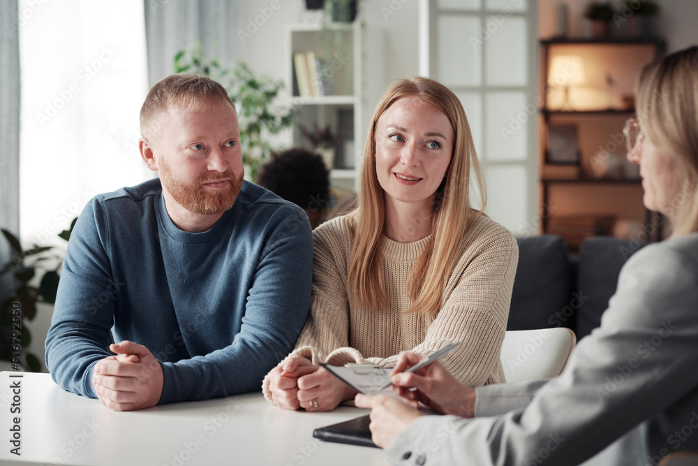 Young couple having an interview with social worker before adoption of ...