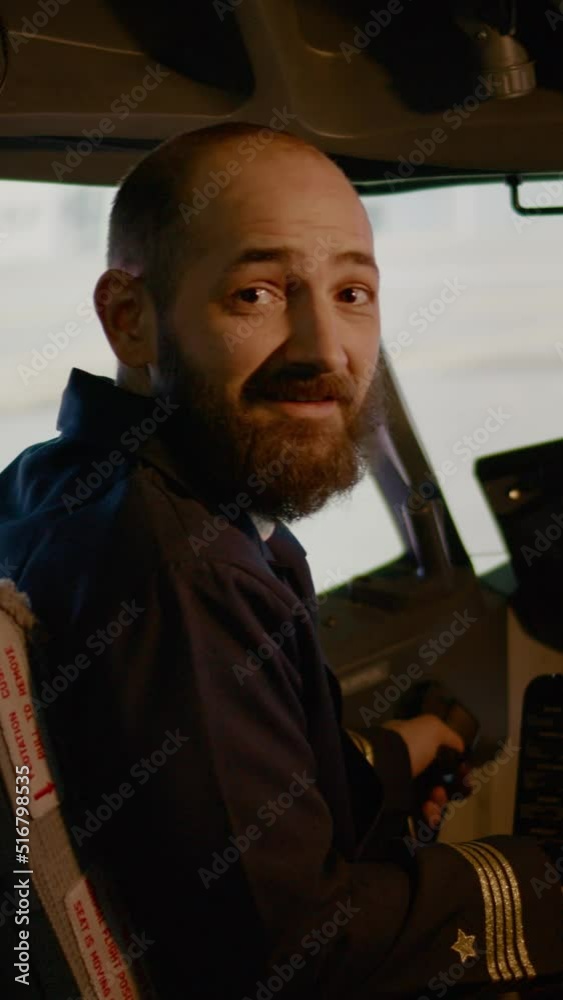 Stockvideon Vertical video: Portrait of airplane captain preparing to ...