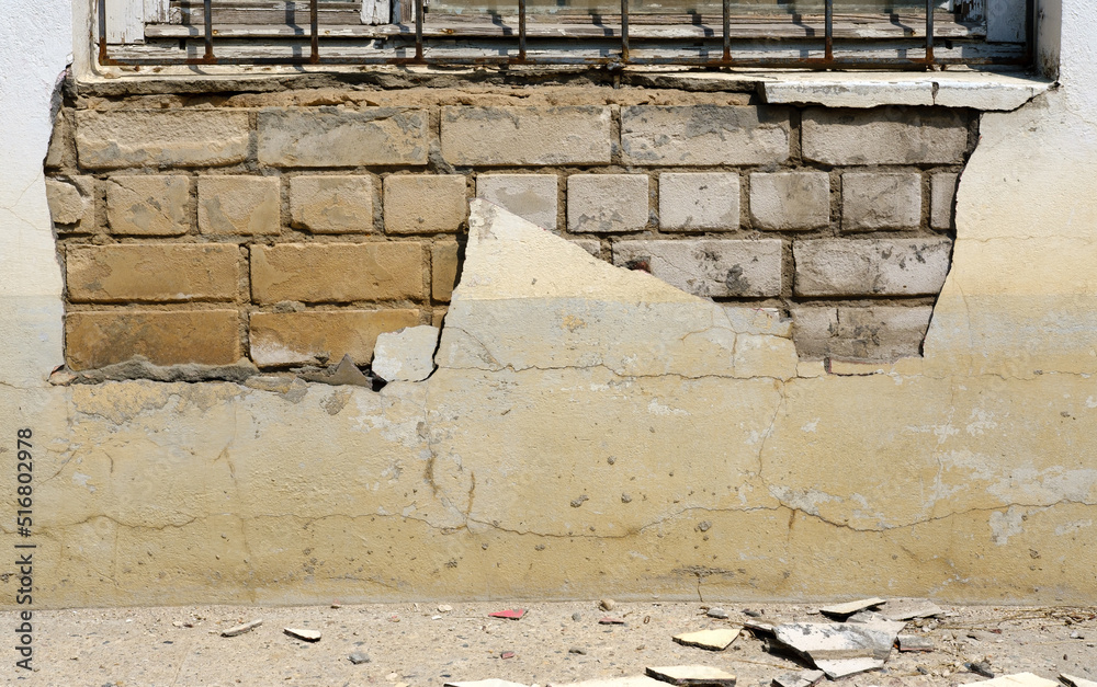 The plaster fell off the wall of the old ruined building under the ...