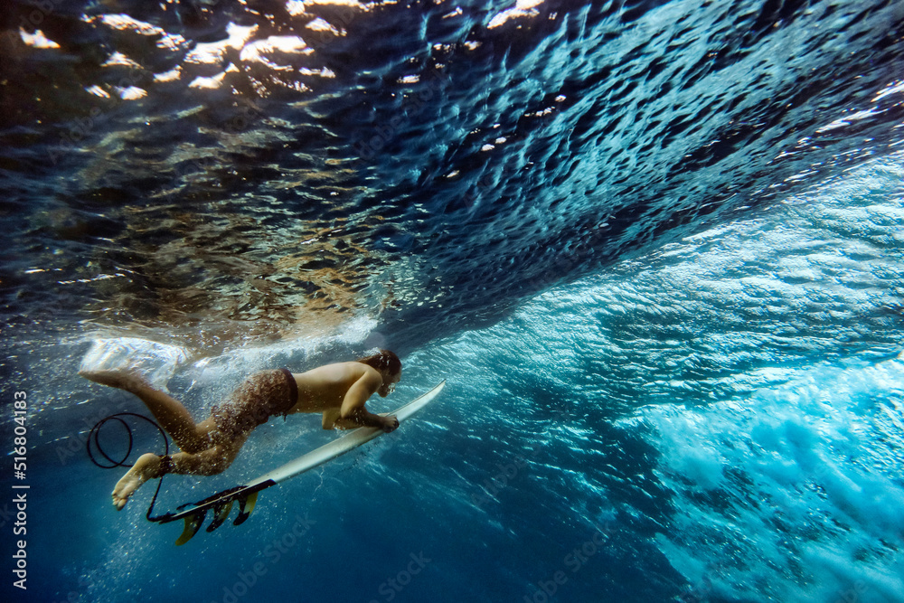 Underwater view of male surfer making duck dive Stock Photo | Adobe Stock
