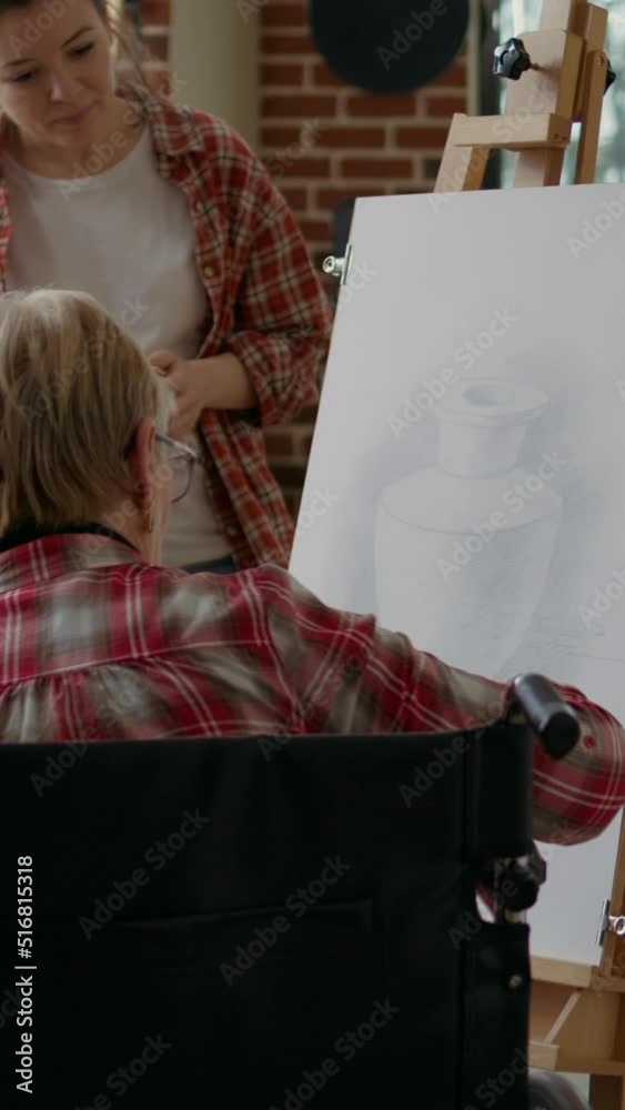 Vertical video: Elder woman with disability attending art class lesson ...