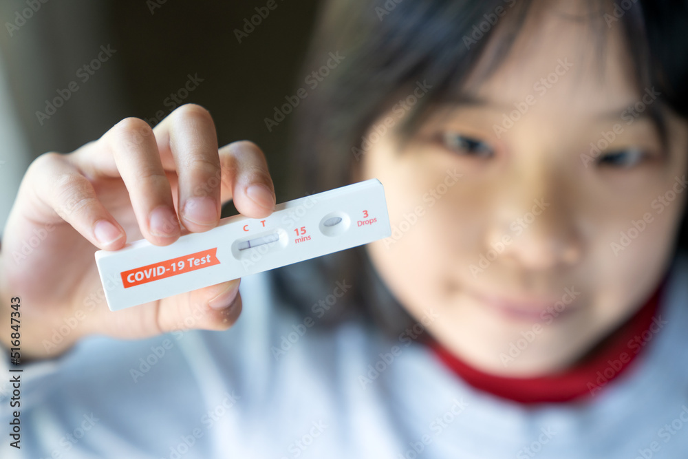 Little girl is showing negative results on rapid antigen test kit for ...