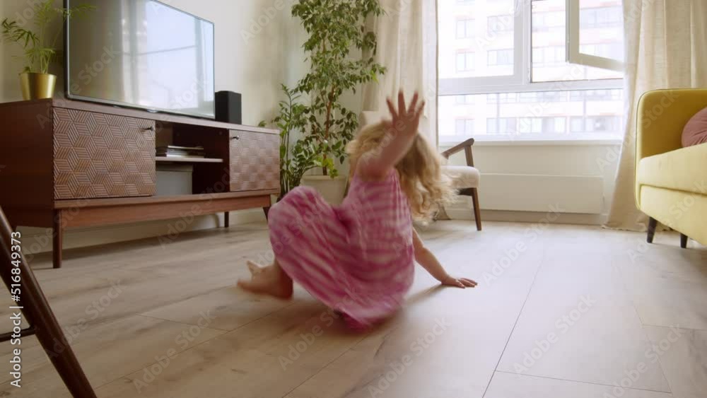 cute blonde girl dancing at home in bright pink dress on floor. child ...