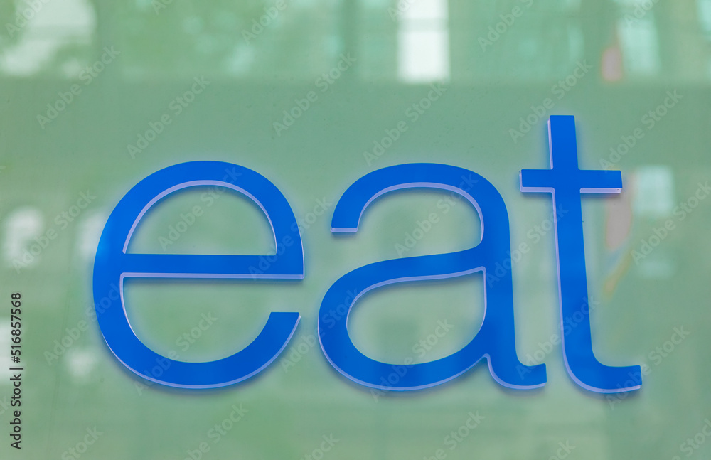 'eat' sign on a glass wall backdrop. Exterior signage and logo Eat here ...