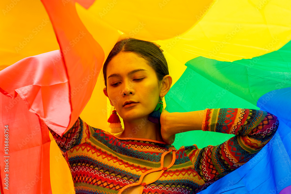 Elegance transgender model woman in colorful rainbow flag costume is ...