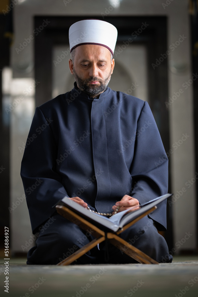 Religious Muslim man praying inside the mosque reading a Quran. Stock ...