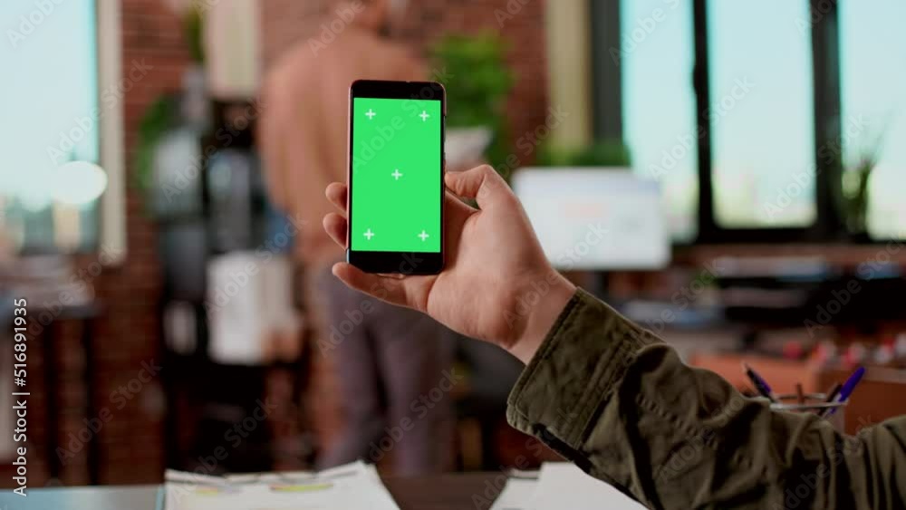 Businessman holding greenscreen display on mobile phone, analyzing ...