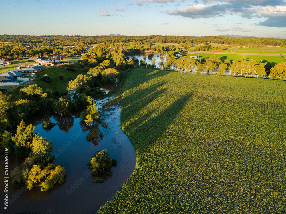 Flooding river backflowing over farm paddocks, drowning farmers crops ...