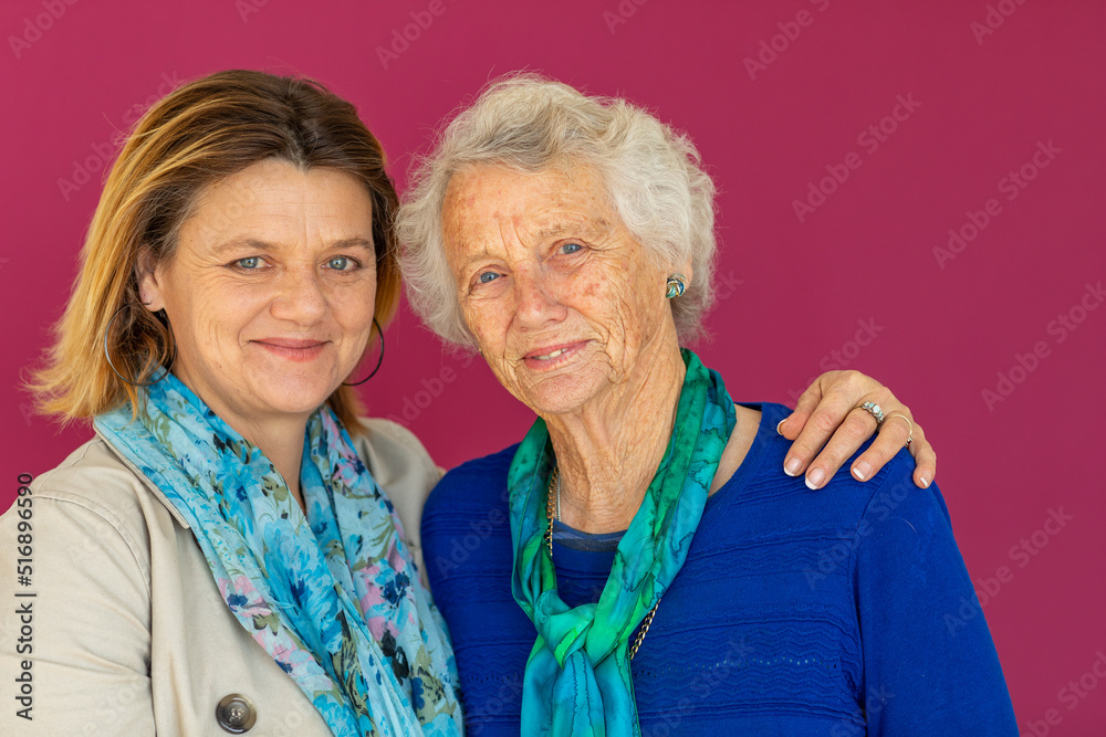 middle-aged woman with her elderly mother against pink background Stock ...