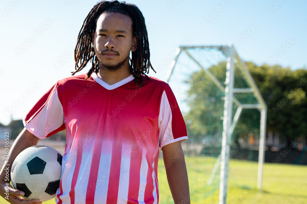 Serious biracial male player with dreadlocks wearing red jersey with ...