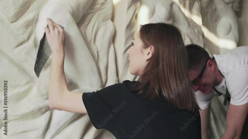 Sculptor and his female assistant work with plaster structural ...