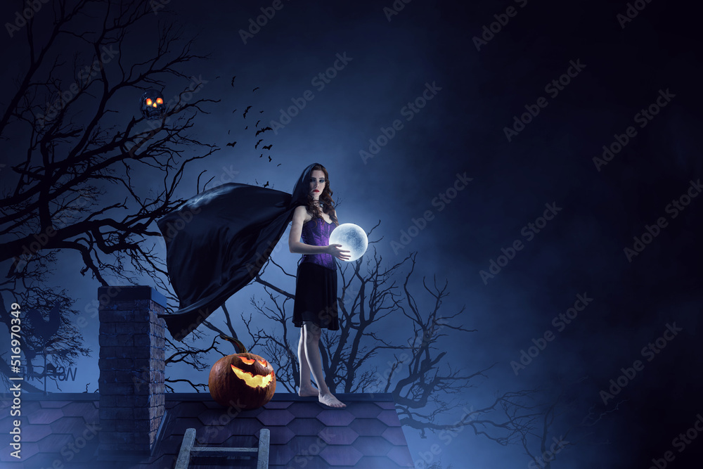 Beautiful young woman in witches hat and costume Stock Photo | Adobe Stock