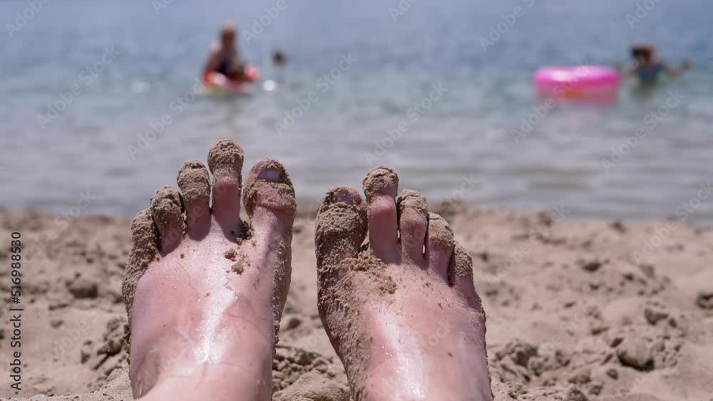 POV Female Wet Feet in Sand Lying on a Sandy Beach in Sun Glare near ...