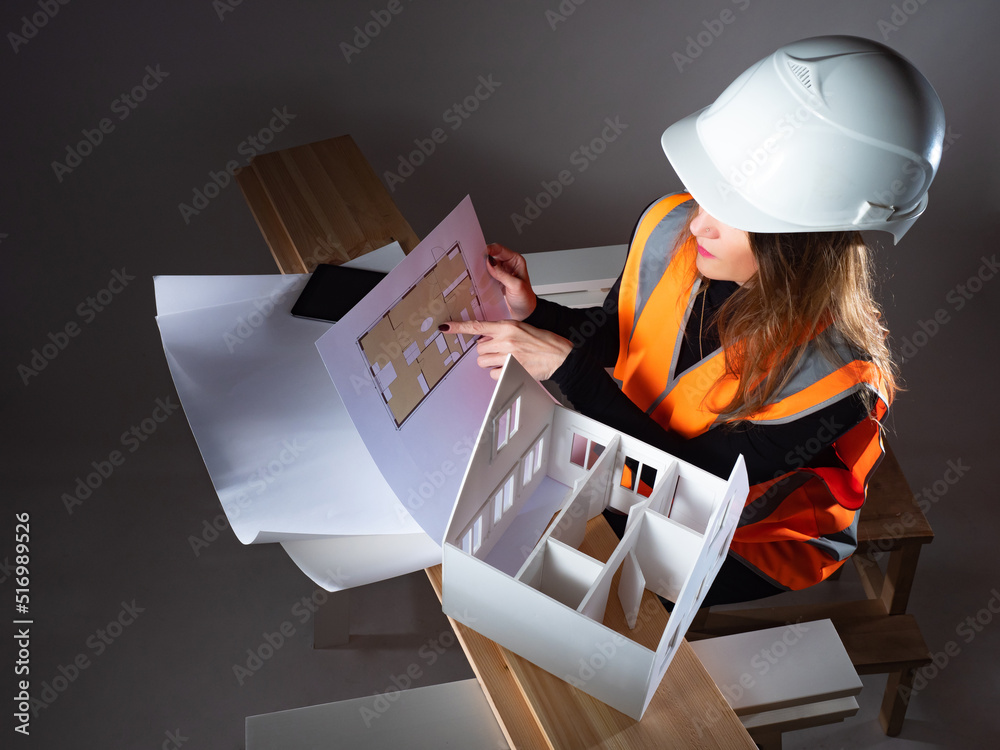 Female architect, layout and drawing of the cottage from above. An ...