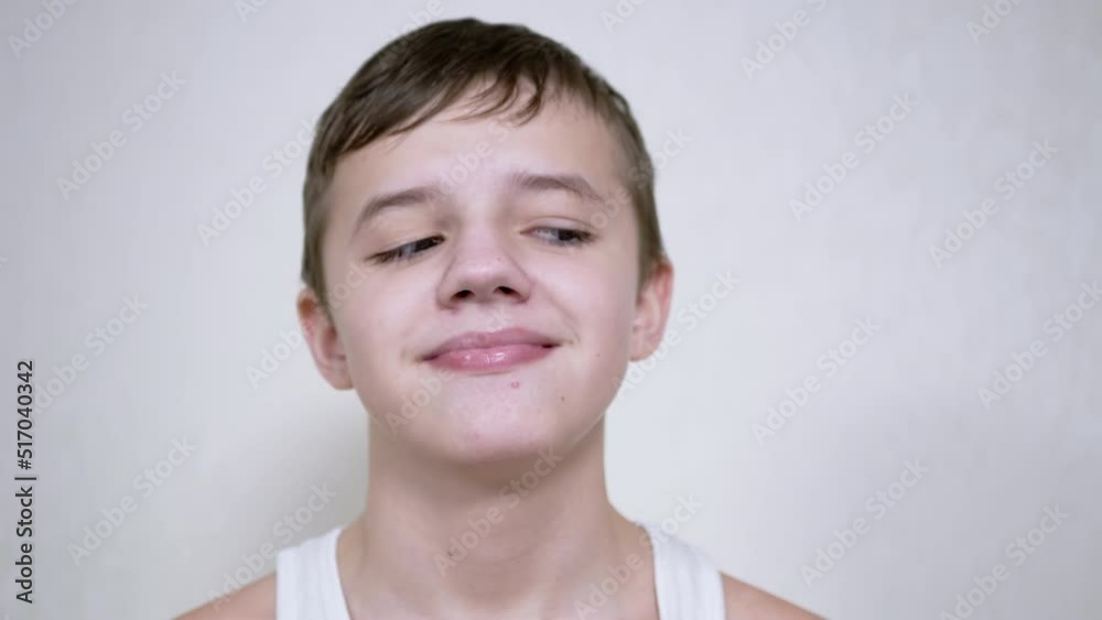 A Smiling Boy with Lowered Eyelids Rotates his Eyes in Different ...