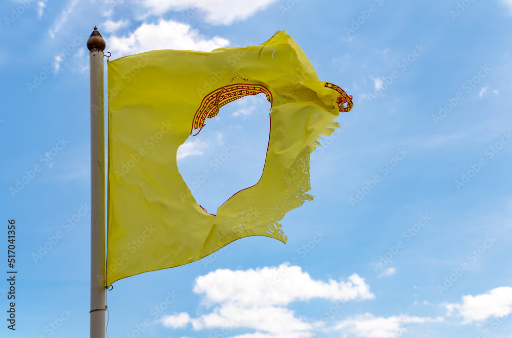 The damaged dhammacakka flag, the symbol of Buddhism in Thailand flying ...