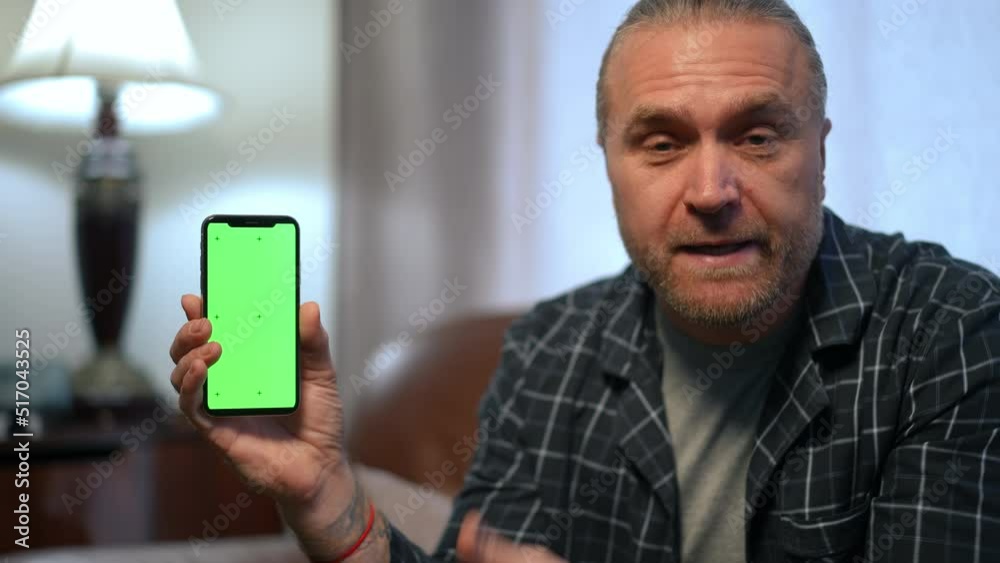 Portrait of confident Caucasian man talking pointing at green screen ...