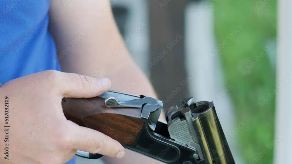 Sportsman shoots from a double-barreled shotgun, A sports field for a ...