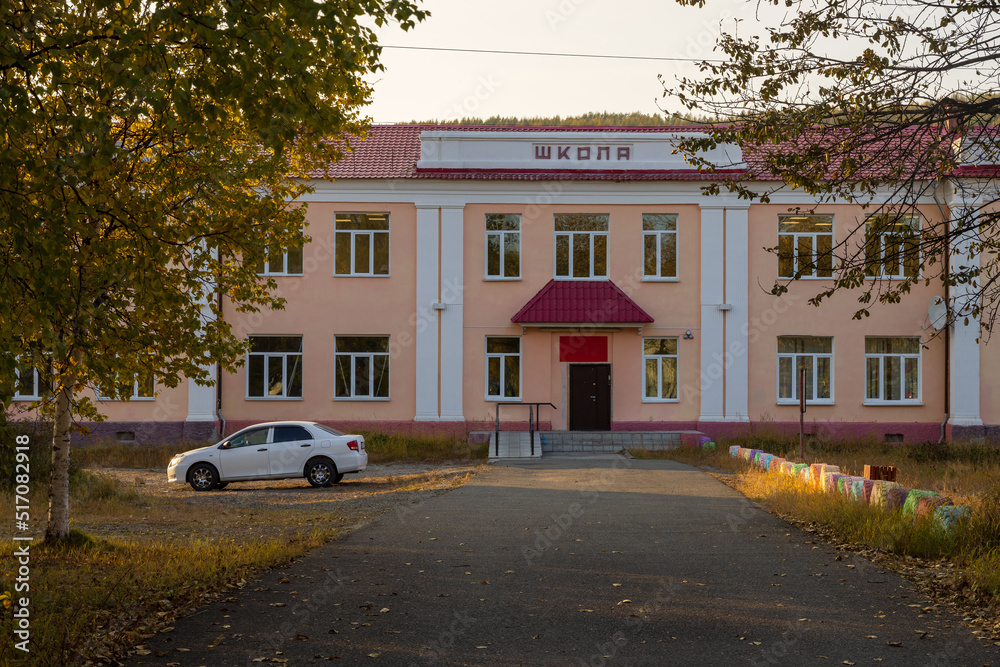 School building. On the facade is the text in Russian "SCHOOL". Empty ...