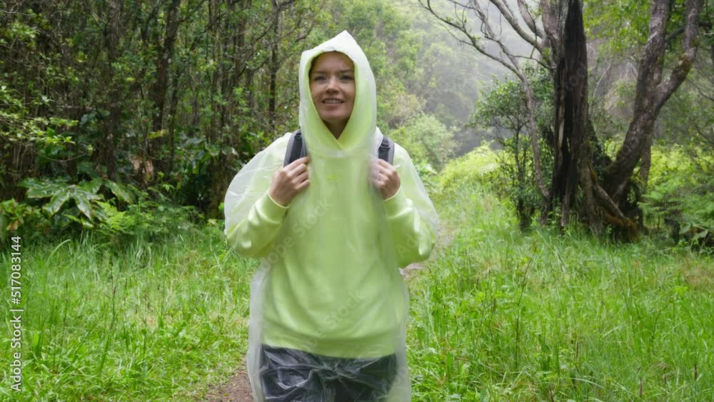 Close up portrait of pretty young woman taking off rain coat hood and ...