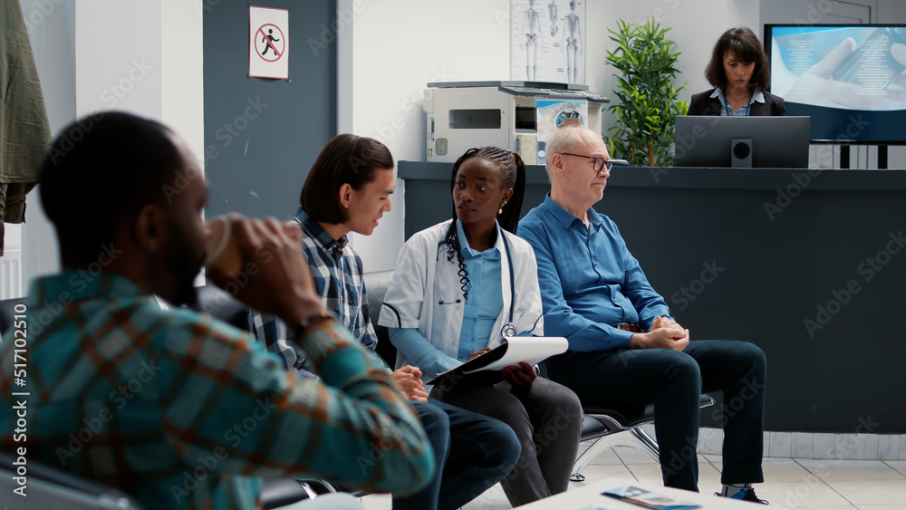 African american physician talking to asian patient in waiting area ...