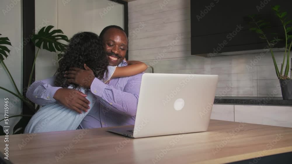 Little African girl runs and hugs her father while he works on his ...