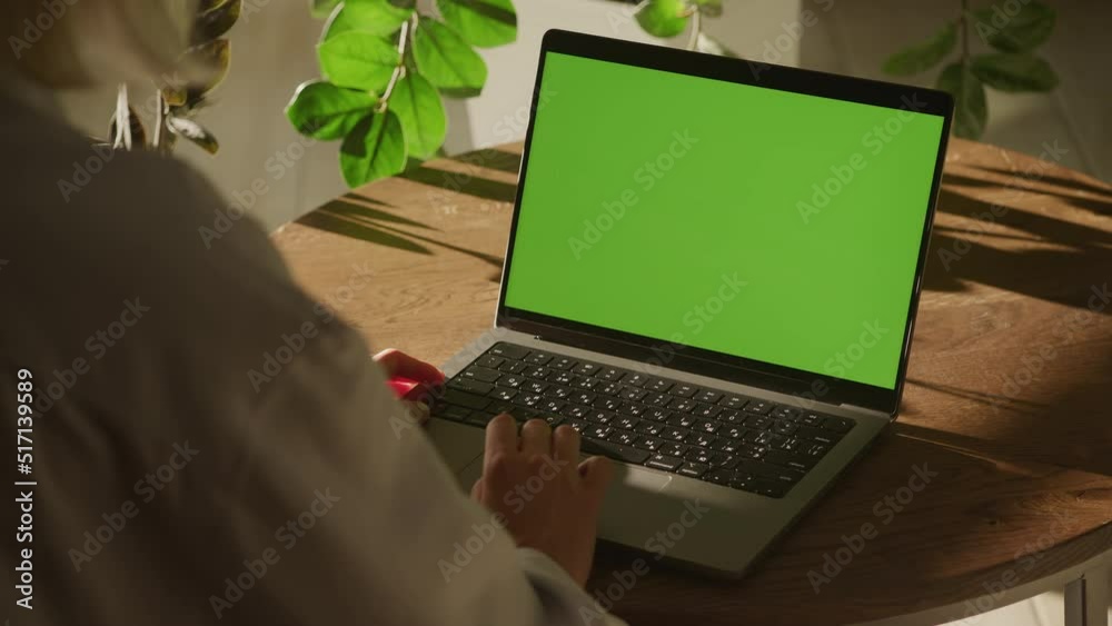 Handheld close up of a woman scrolling on a laptop computer touchpad ...