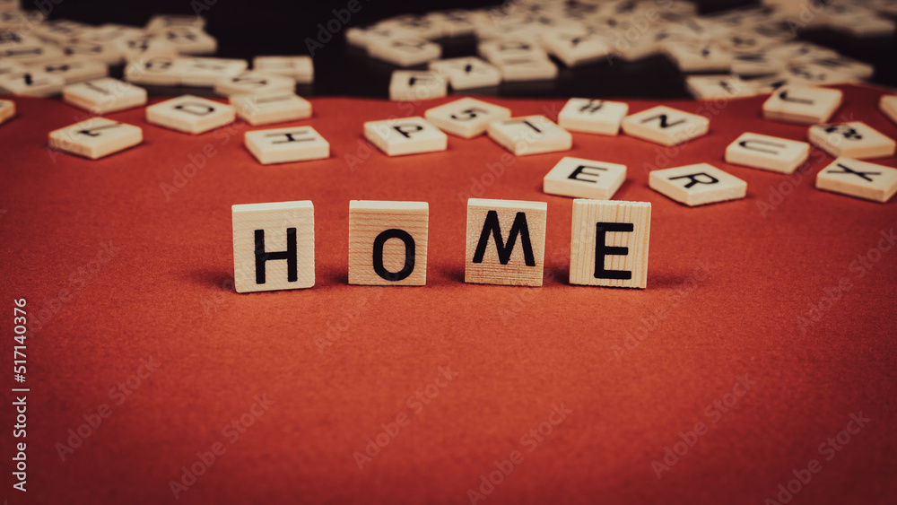 Word "Home" composed of wooden tiles with letters on a red felt ...
