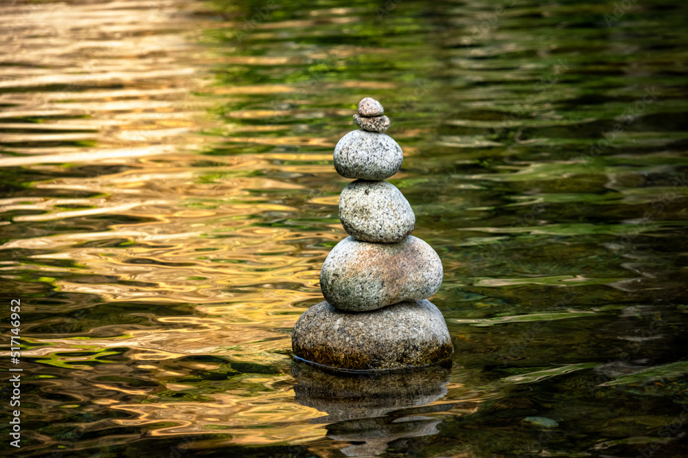 piedras en equilibrio en un río en posición yen Stock Photo | Adobe Stock